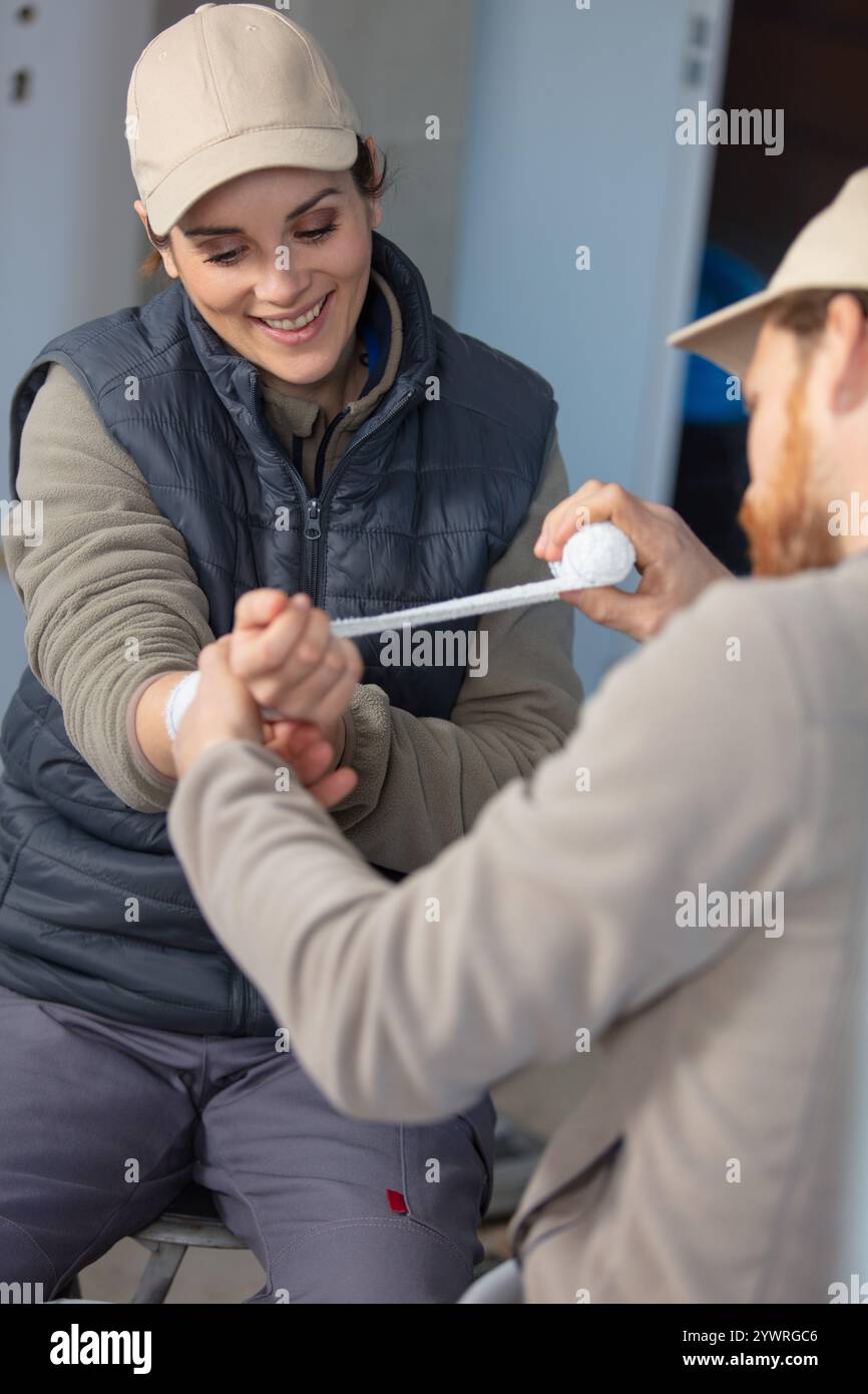 a woman helping man worker after an accident Stock Photo - Alamy