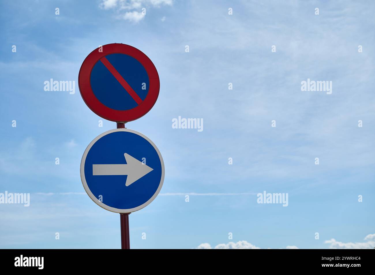 Two traffic signs show no parking allowed and a right turn direction on ...