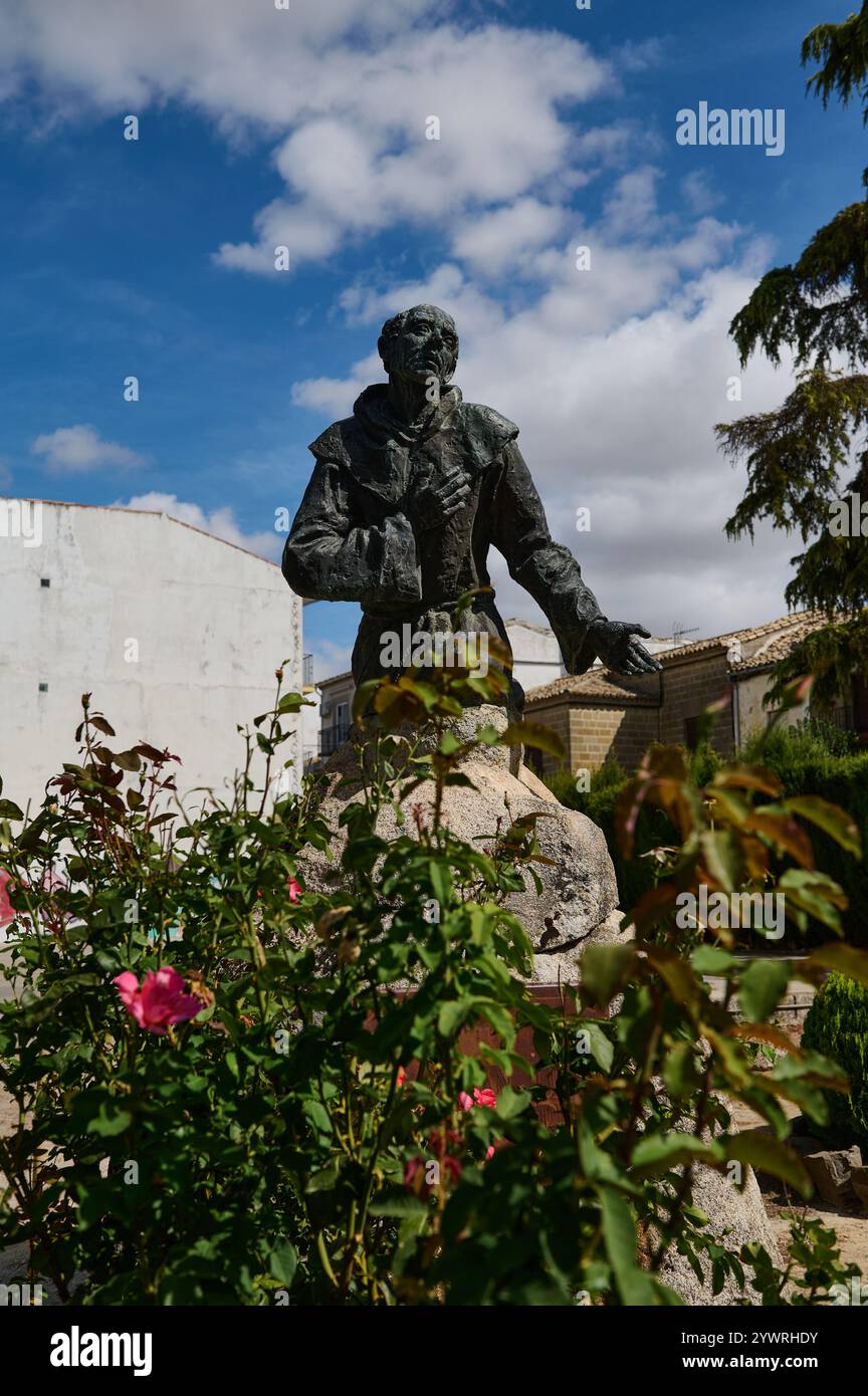 A striking bronze statue stands amidst colorful roses in a historic ...