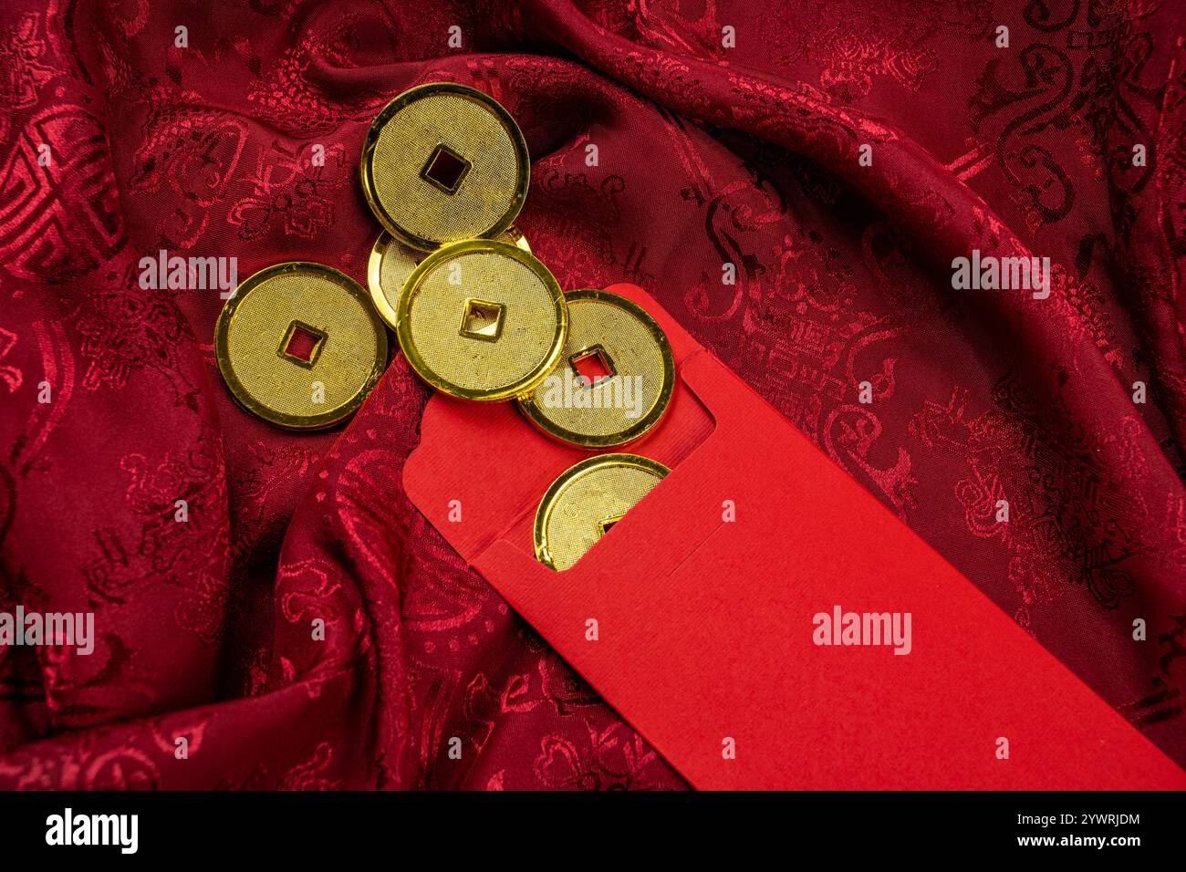 Red envelopes or angpao with golden Chinese coins on a red cloth ...