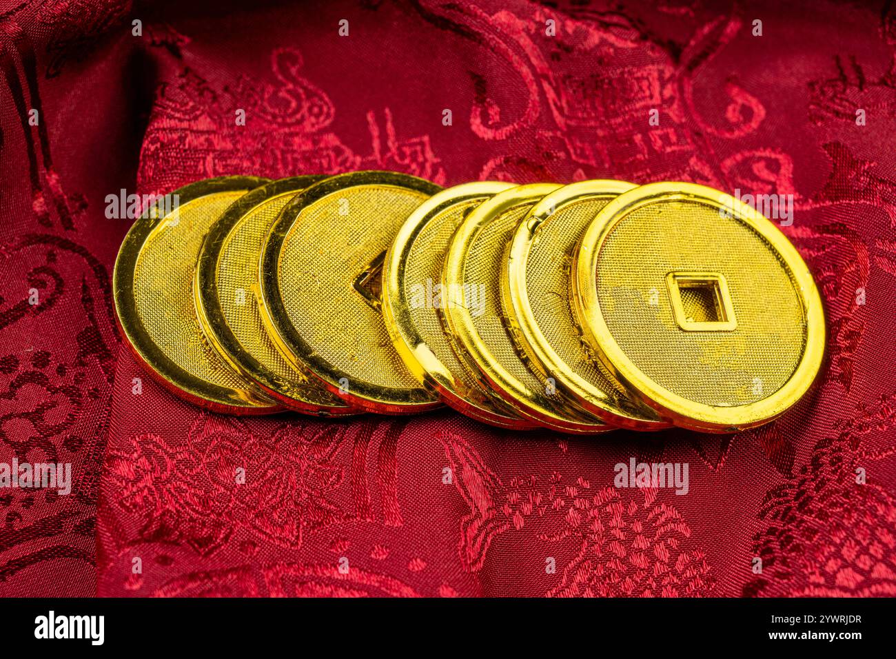 Traditional Chinese golden coins on a red cloth background. Symbol of ...