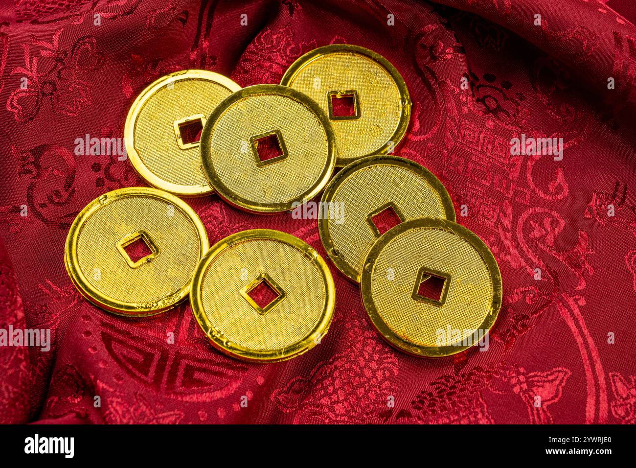 Traditional Chinese golden coins on a red cloth background. Symbol of ...