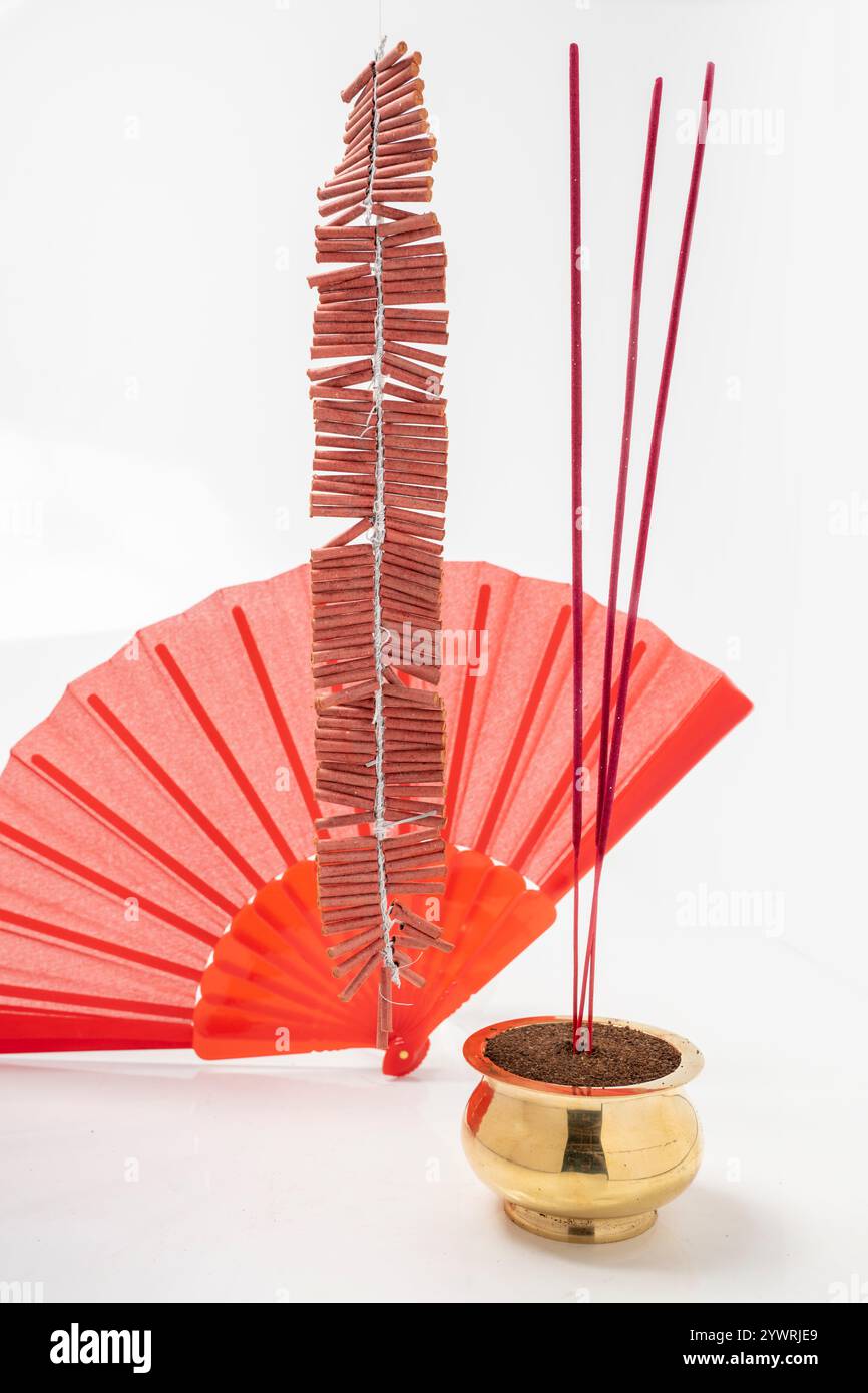Incense on the pot with a folding fan and a string of Chinese ...