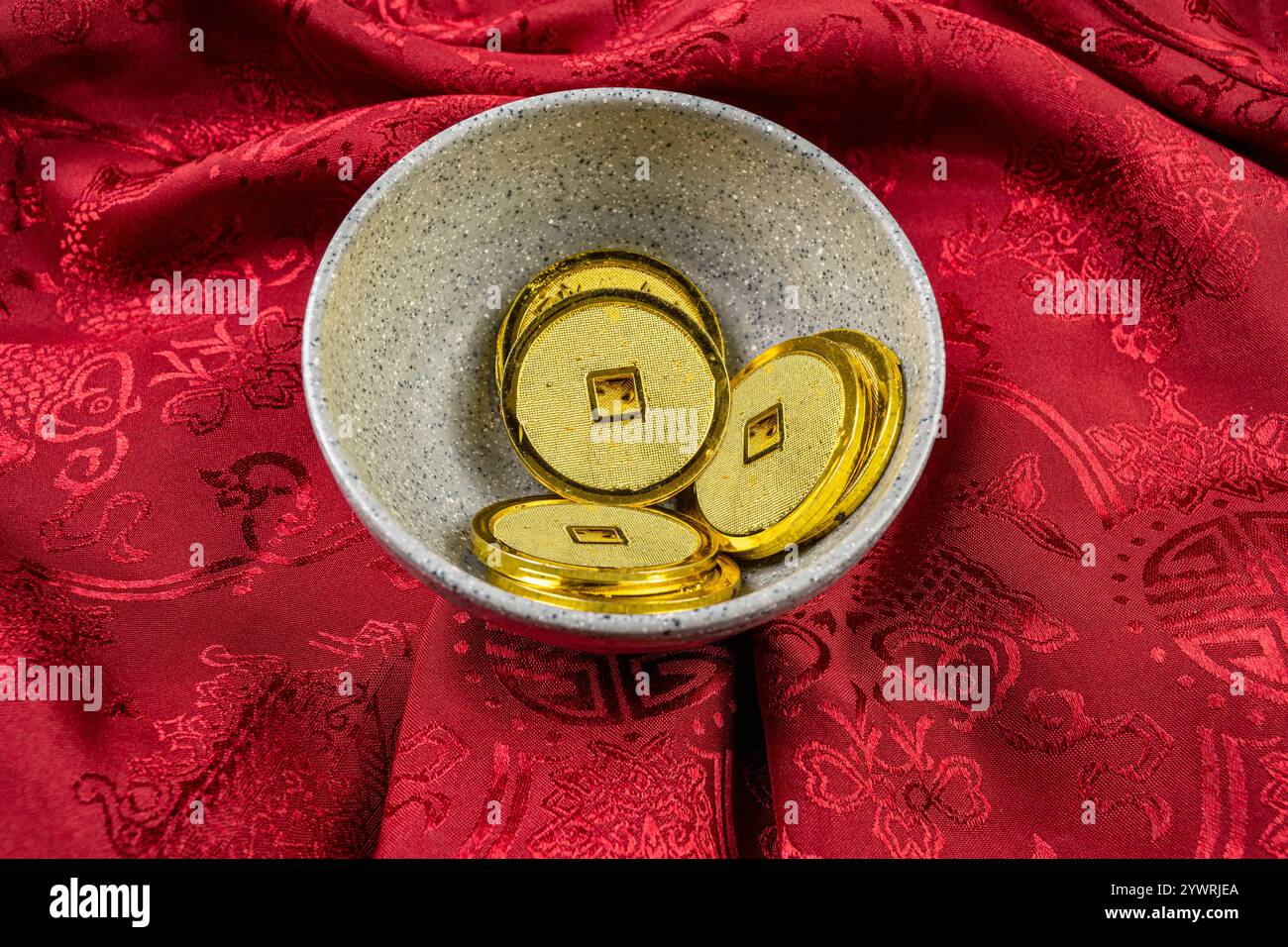 Traditional Chinese golden coins on the bowl with a red cloth ...