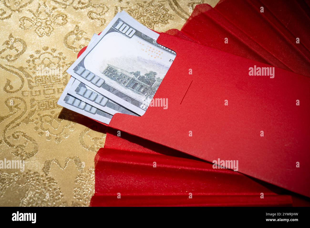 Red envelopes or angpao with banknotes and folding fan on a yellow ...