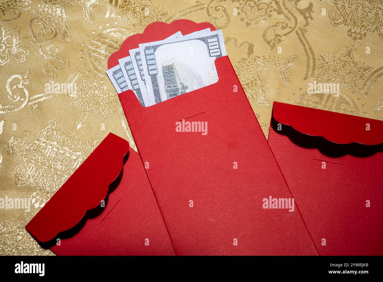 The pile of red envelopes or angpao with banknotes on a yellow cloth ...