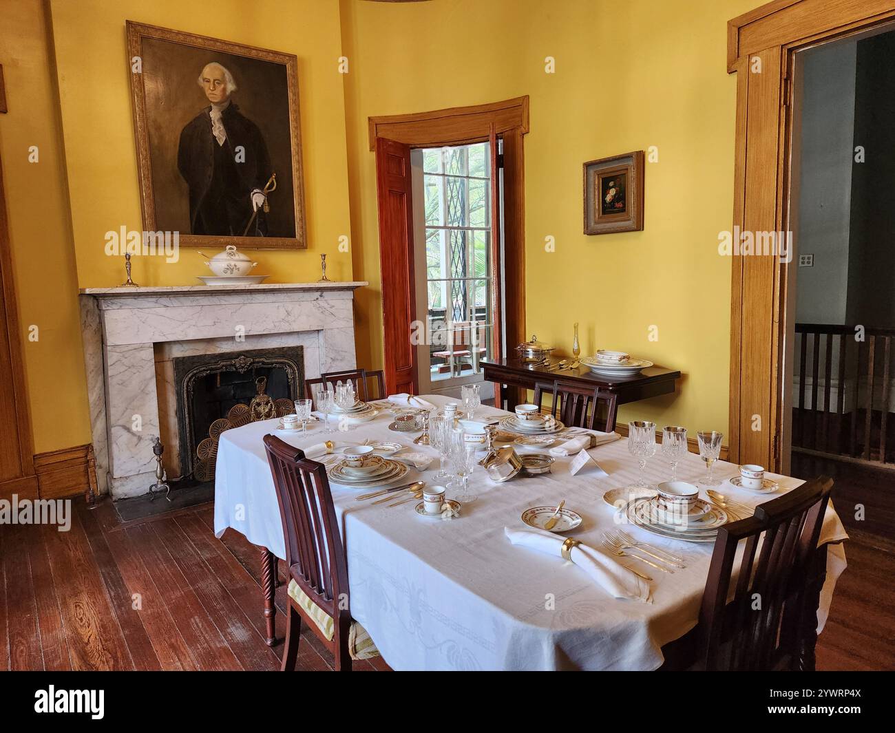 Dining room with golden yellow walls, a fireplace, and a fully set ...