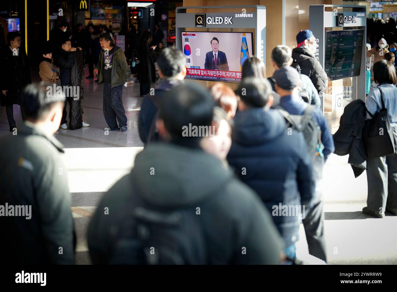 People watch a TV screen showing the live broadcast of South Korean ...