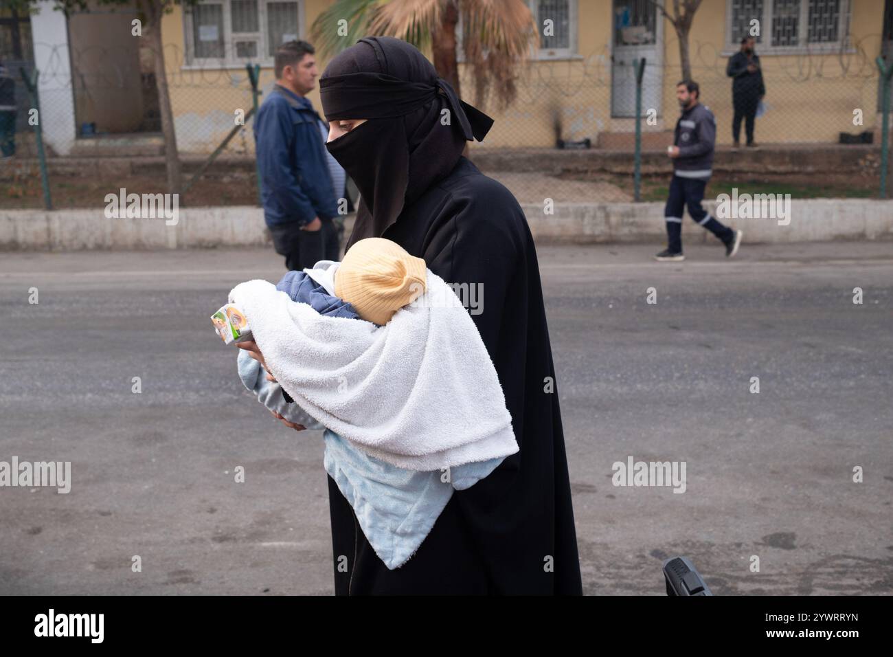 A Syrian woman with her baby at the border. Islamist-led opposition ...