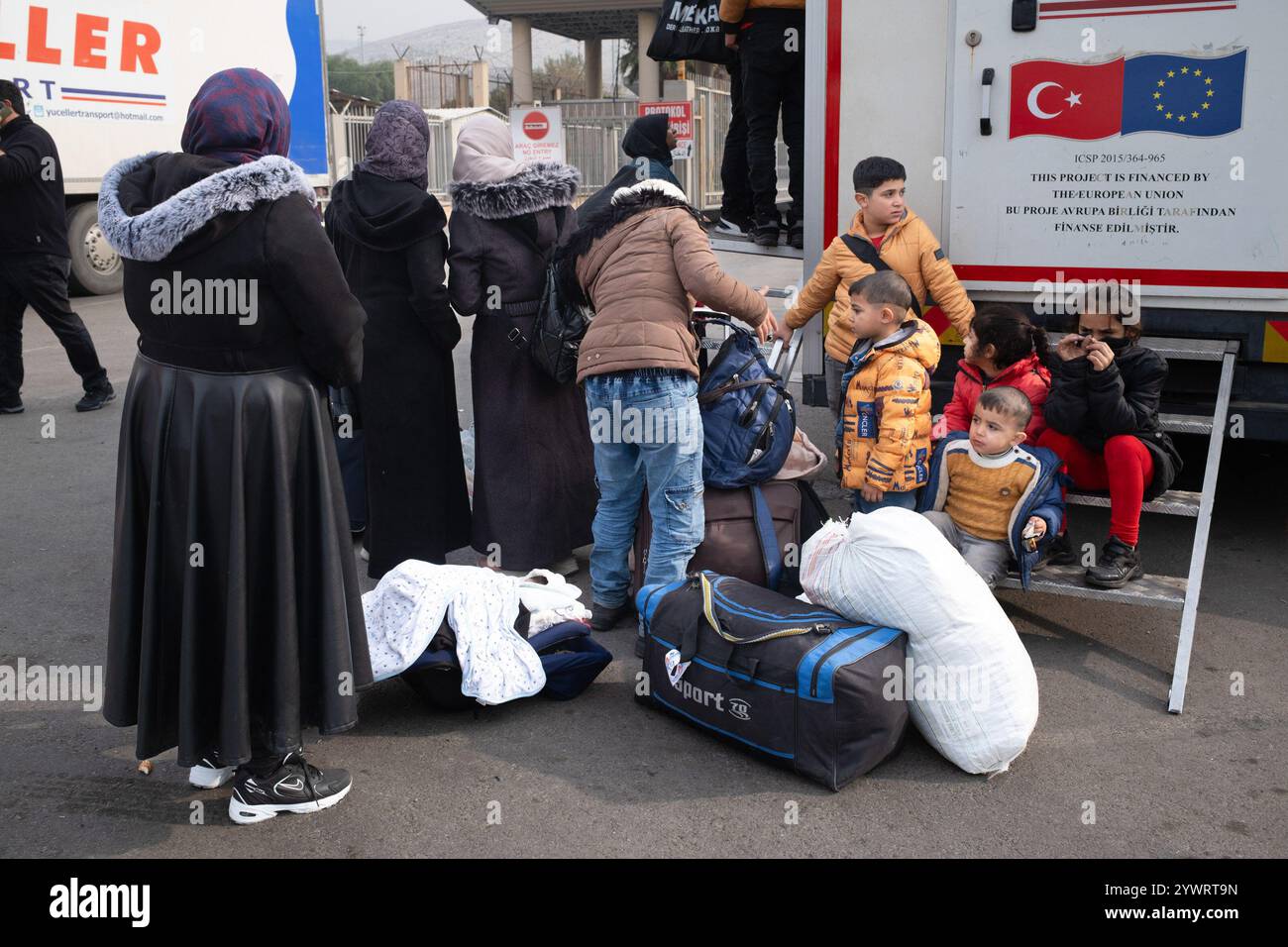 Syrian families are seen waiting to cross the border. Islamist-led ...