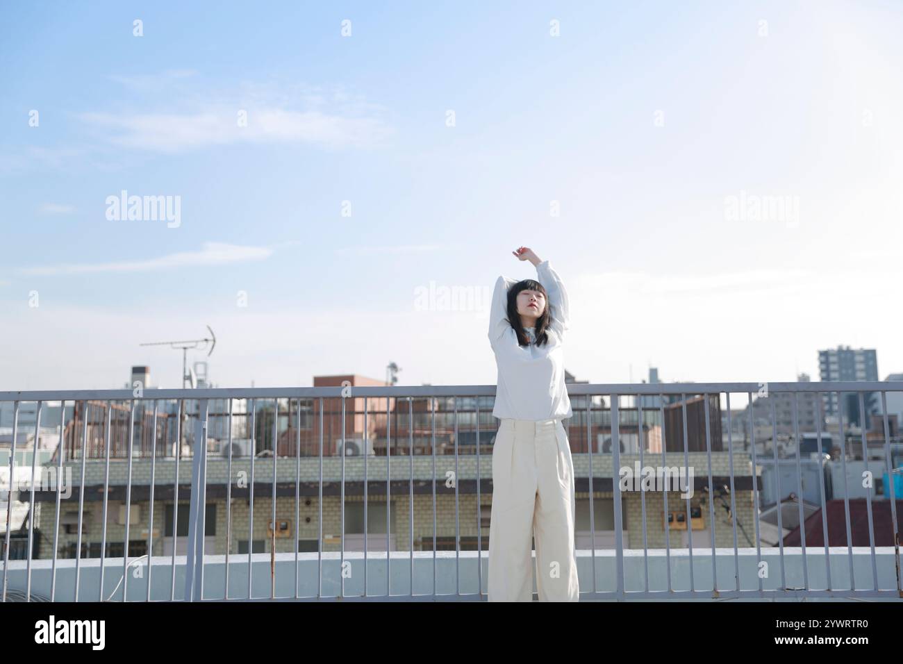 Woman stretching tall on rooftop Stock Photo - Alamy