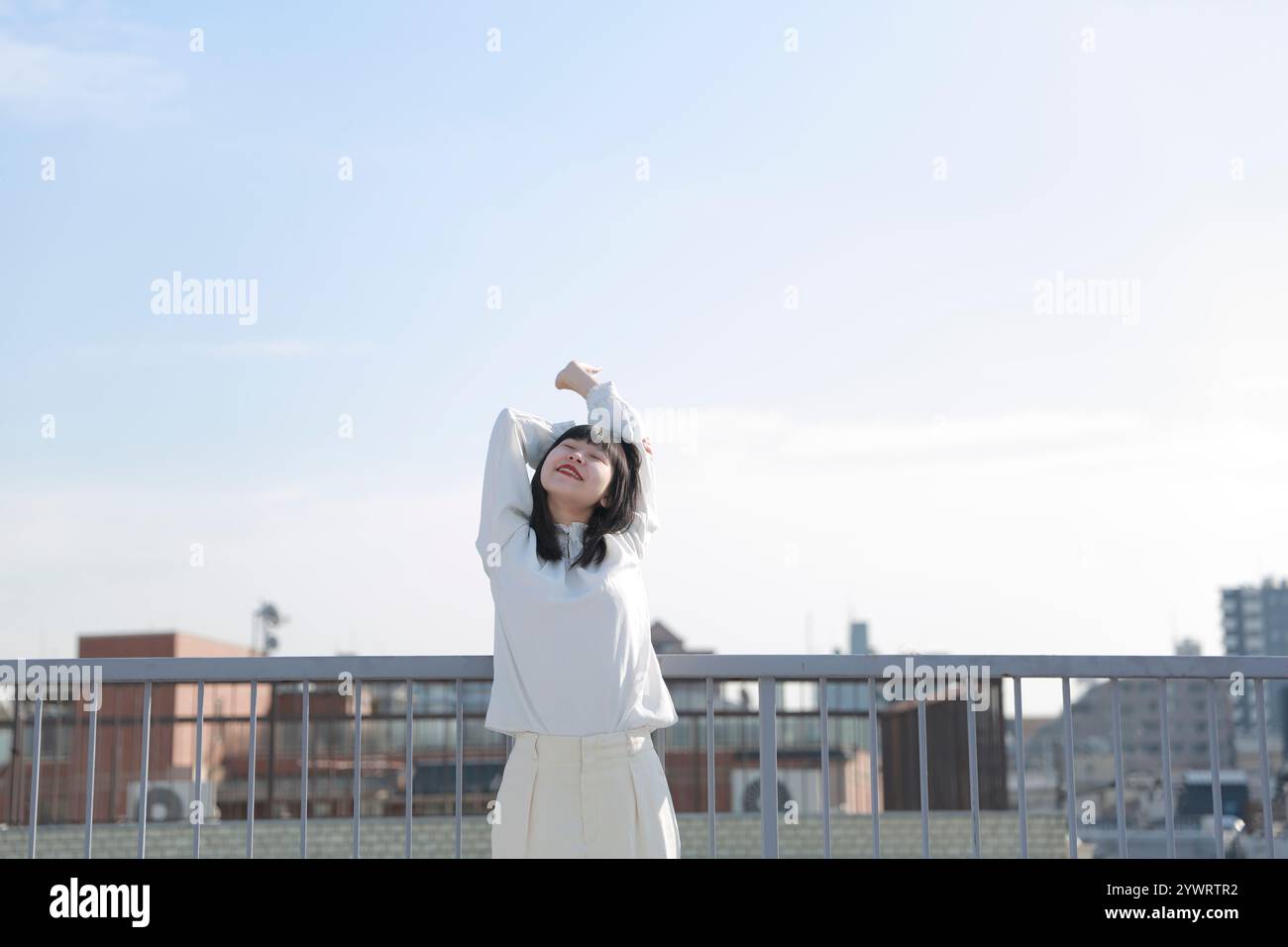 Woman stretching tall on rooftop Stock Photo - Alamy