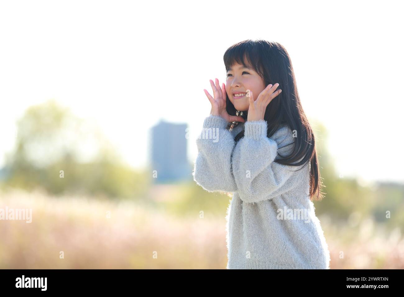 Smiling girl with both hands on cheeks Stock Photo - Alamy
