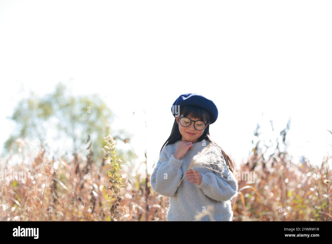 Girl in blue beret with glasses staring at plant with hand on chin ...