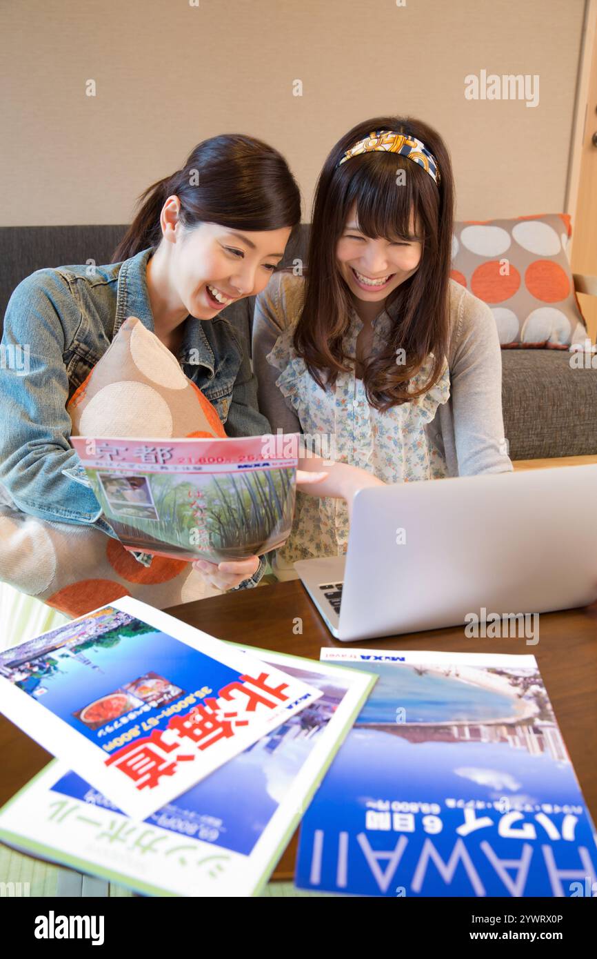 Two young women planning a trip Stock Photo - Alamy