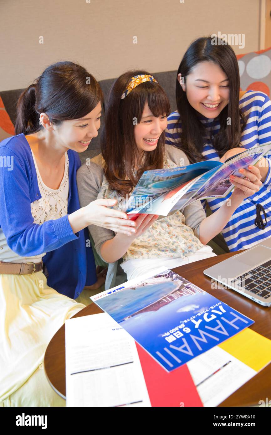 Three young women planning a trip Stock Photo - Alamy