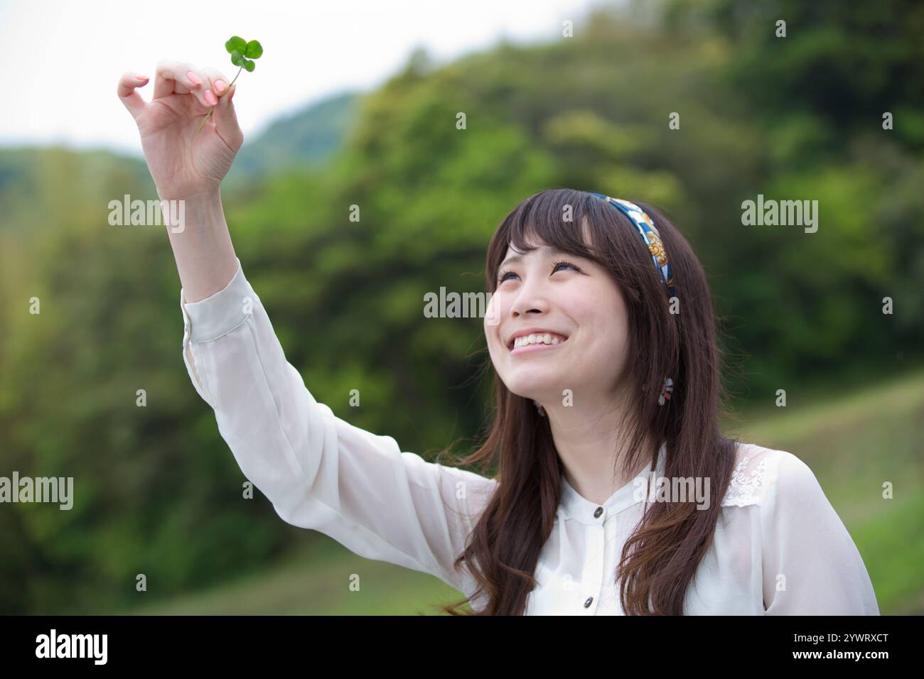 Young woman holding four-leaf clover Stock Photo - Alamy