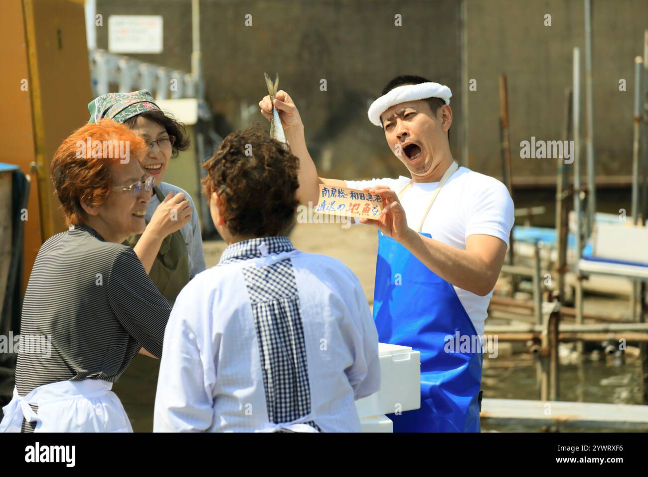 Fresh fish shopkeeper selling fish outdoors with female customers Stock ...