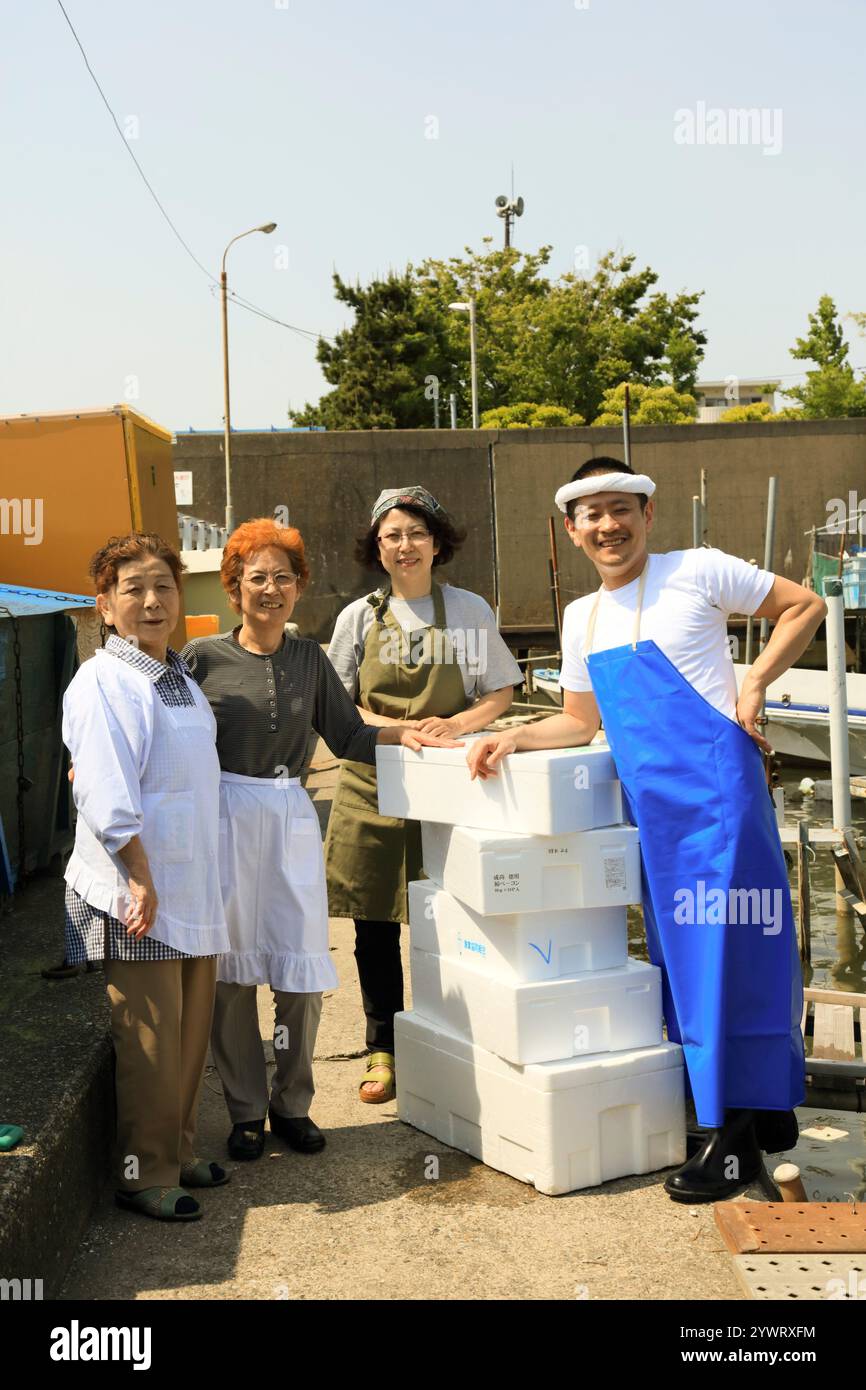 Fresh fish shopkeeper selling fish outdoors with female customers Stock ...