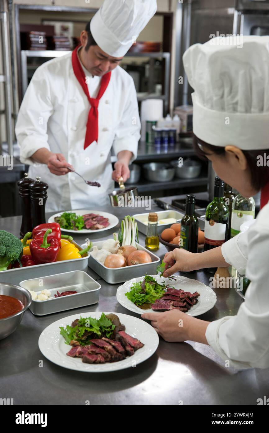 Cook serving a plate of steak Stock Photo - Alamy