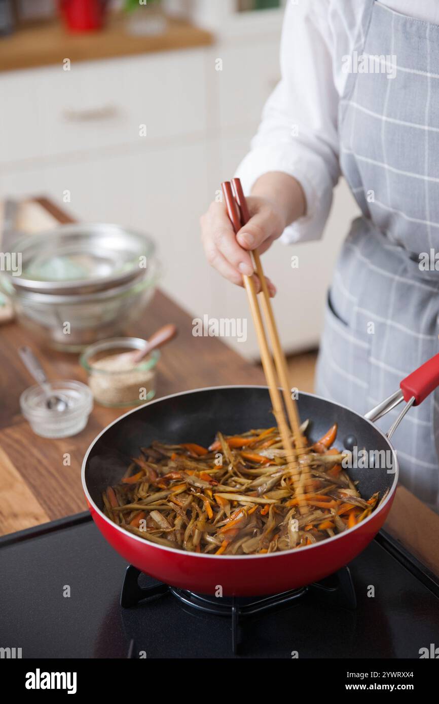 Woman finishing the kinpira gobo Stock Photo - Alamy
