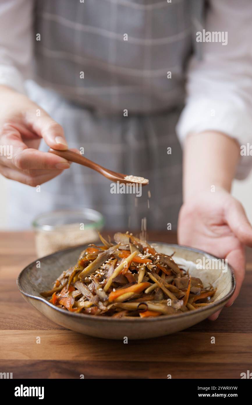 Hand sprinkling sesame seeds on hi-res stock photography and images - Alamy