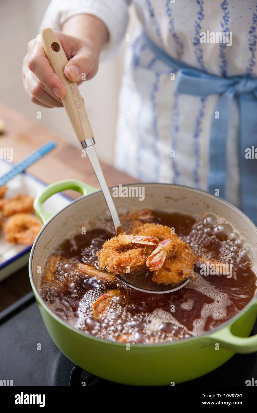 Woman frying fried prawns in oil Stock Photo - Alamy