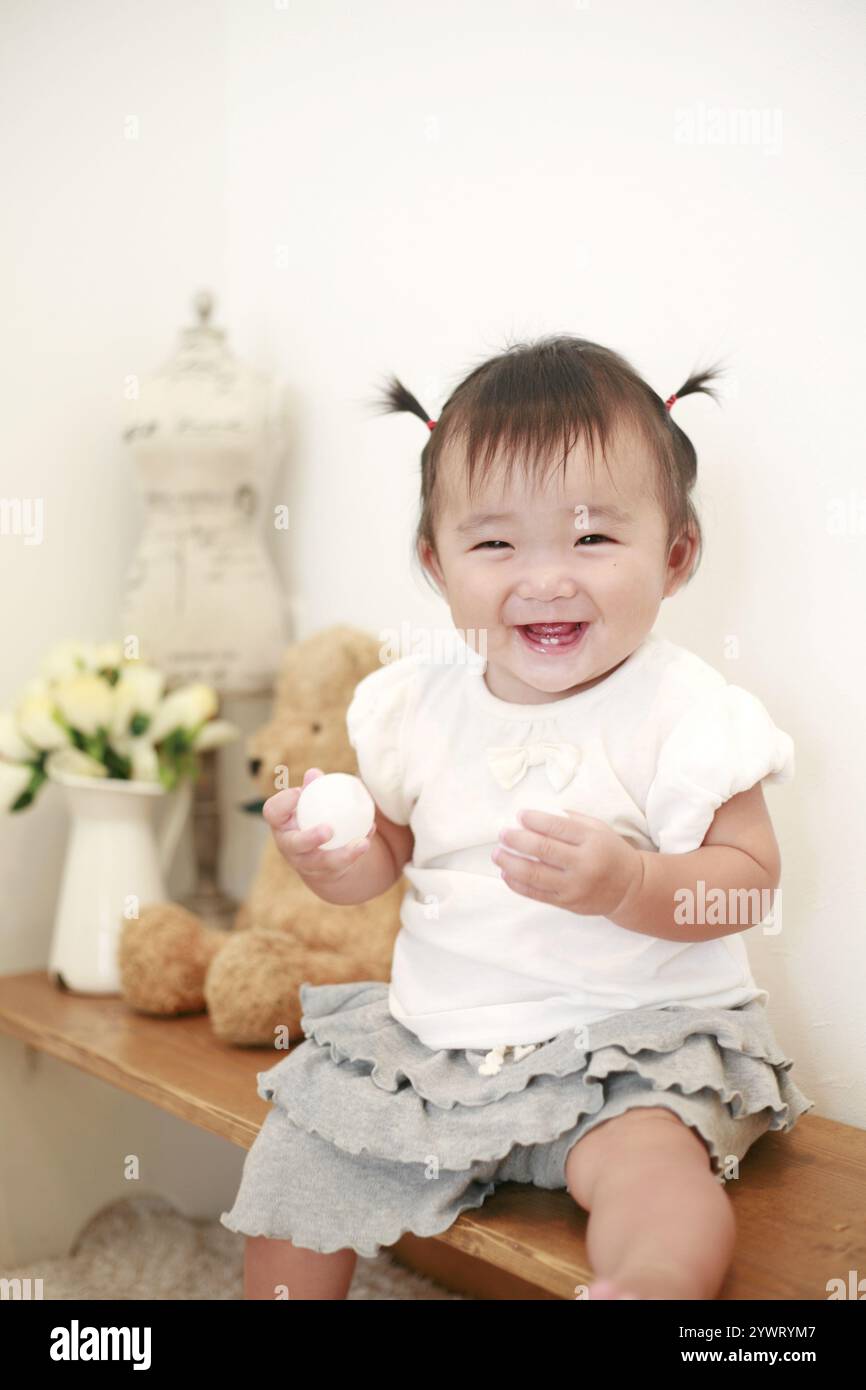 Smiling baby girl sitting on bench Stock Photo - Alamy