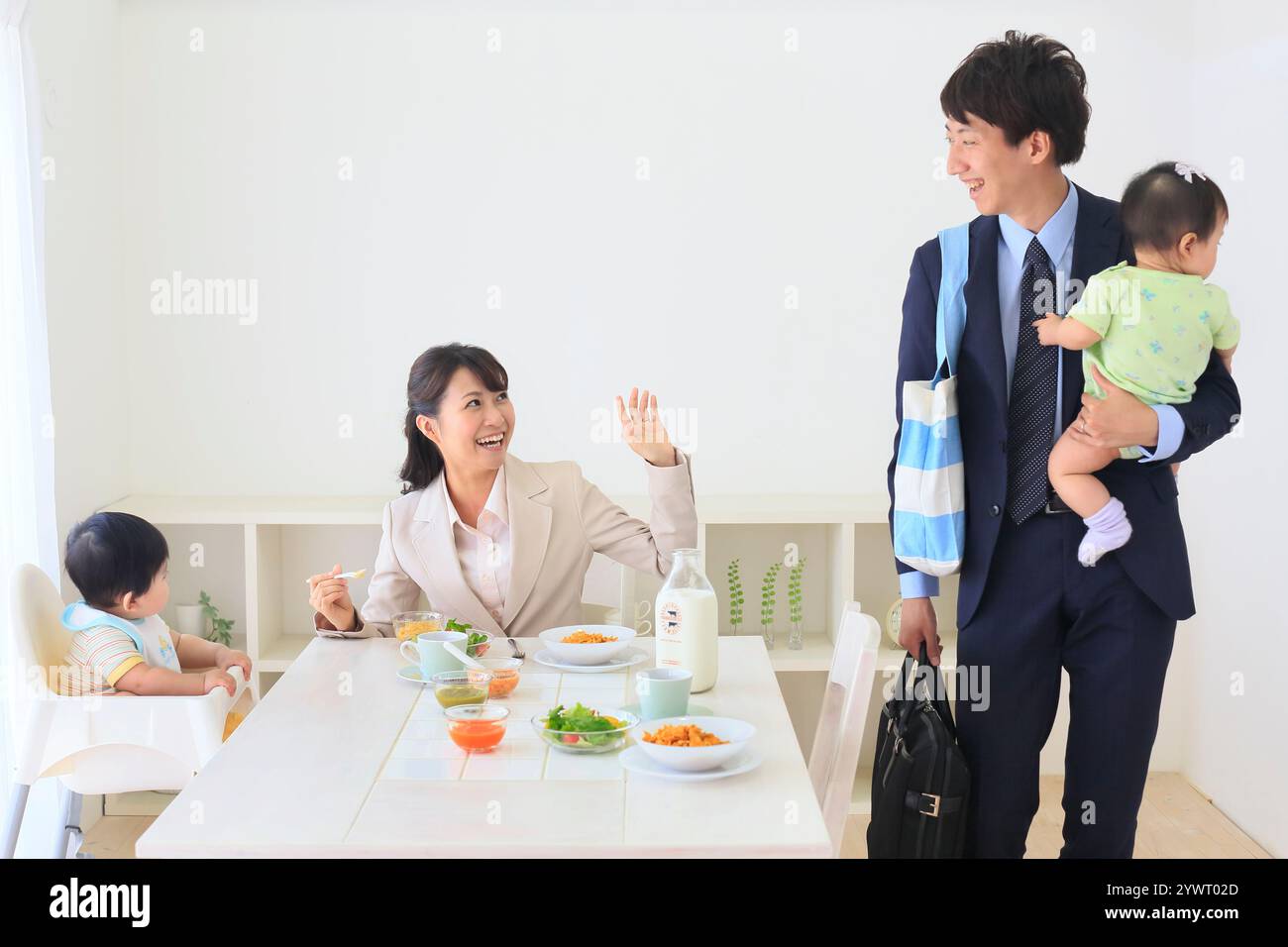 A working couple and their twin babies hurriedly getting ready for work ...