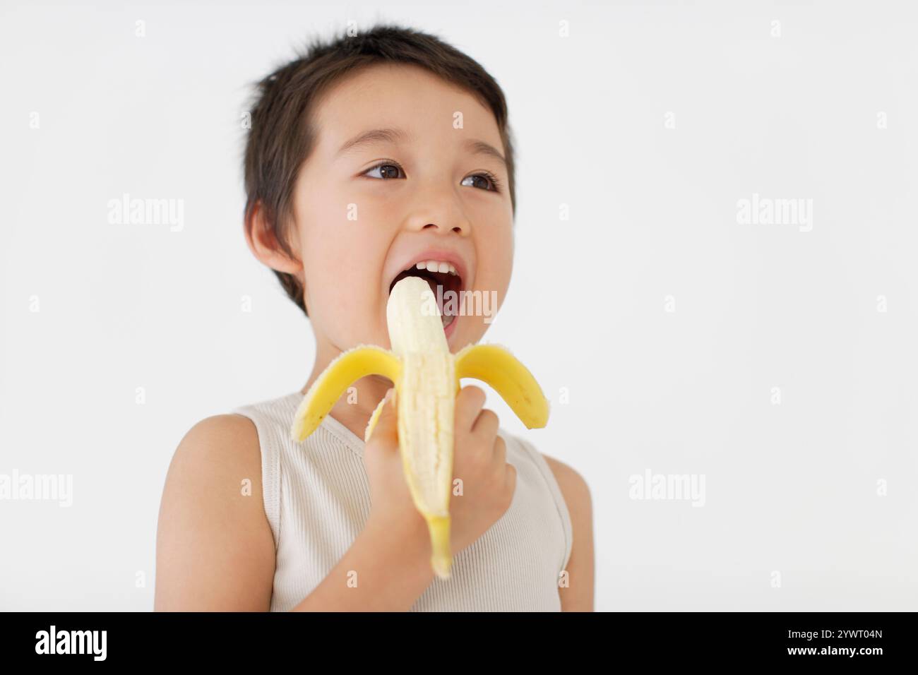 Boy eating banana Stock Photo - Alamy