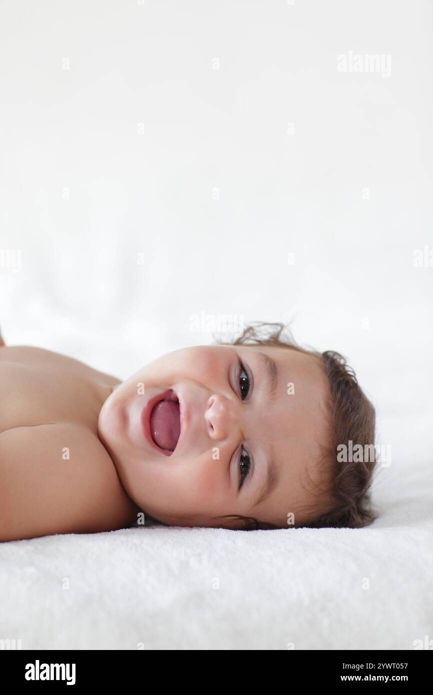Foreign baby lying on bed Stock Photo - Alamy