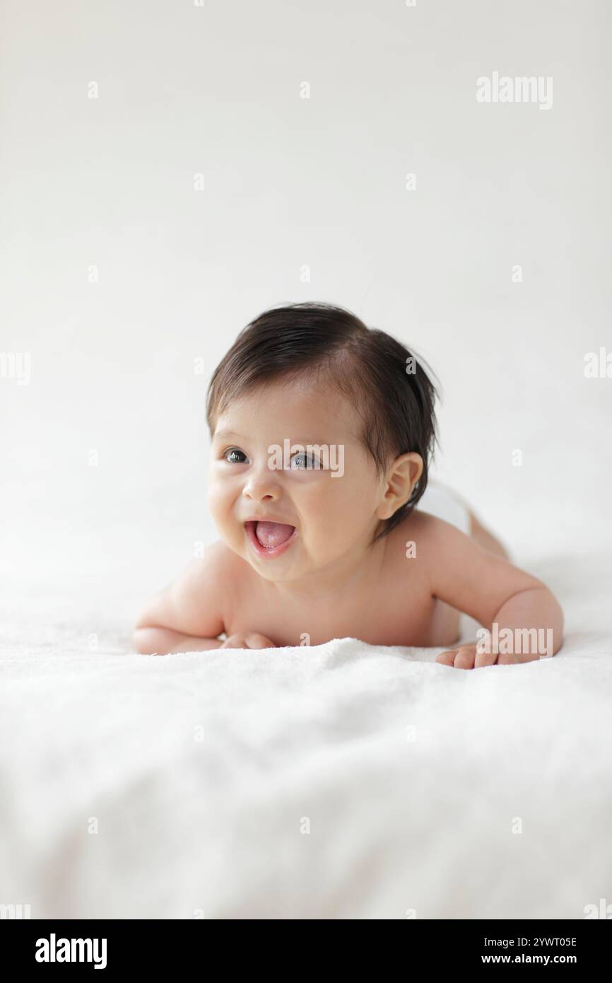 Foreign baby lying in bed Stock Photo - Alamy