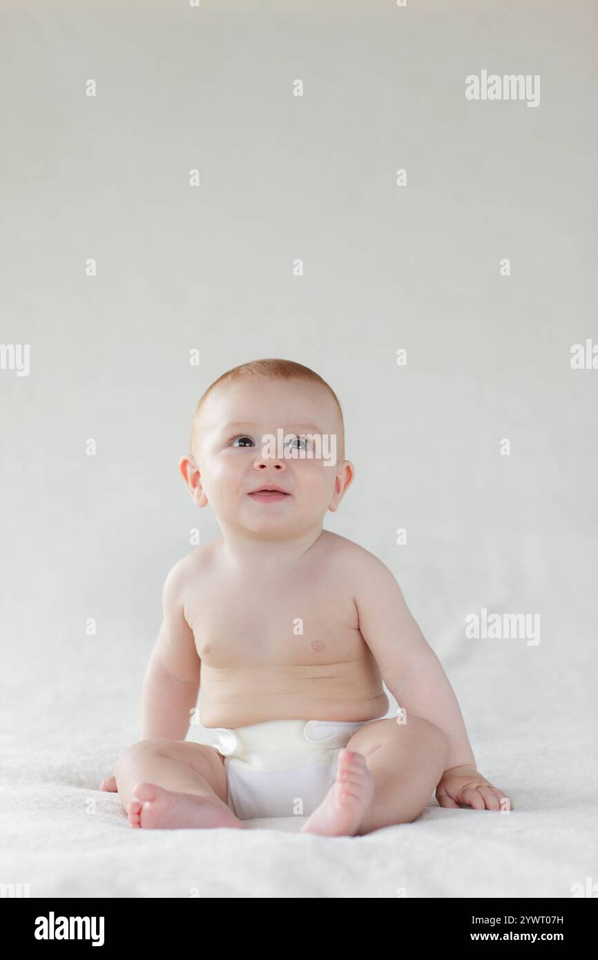 Foreign baby sitting on bed Stock Photo - Alamy