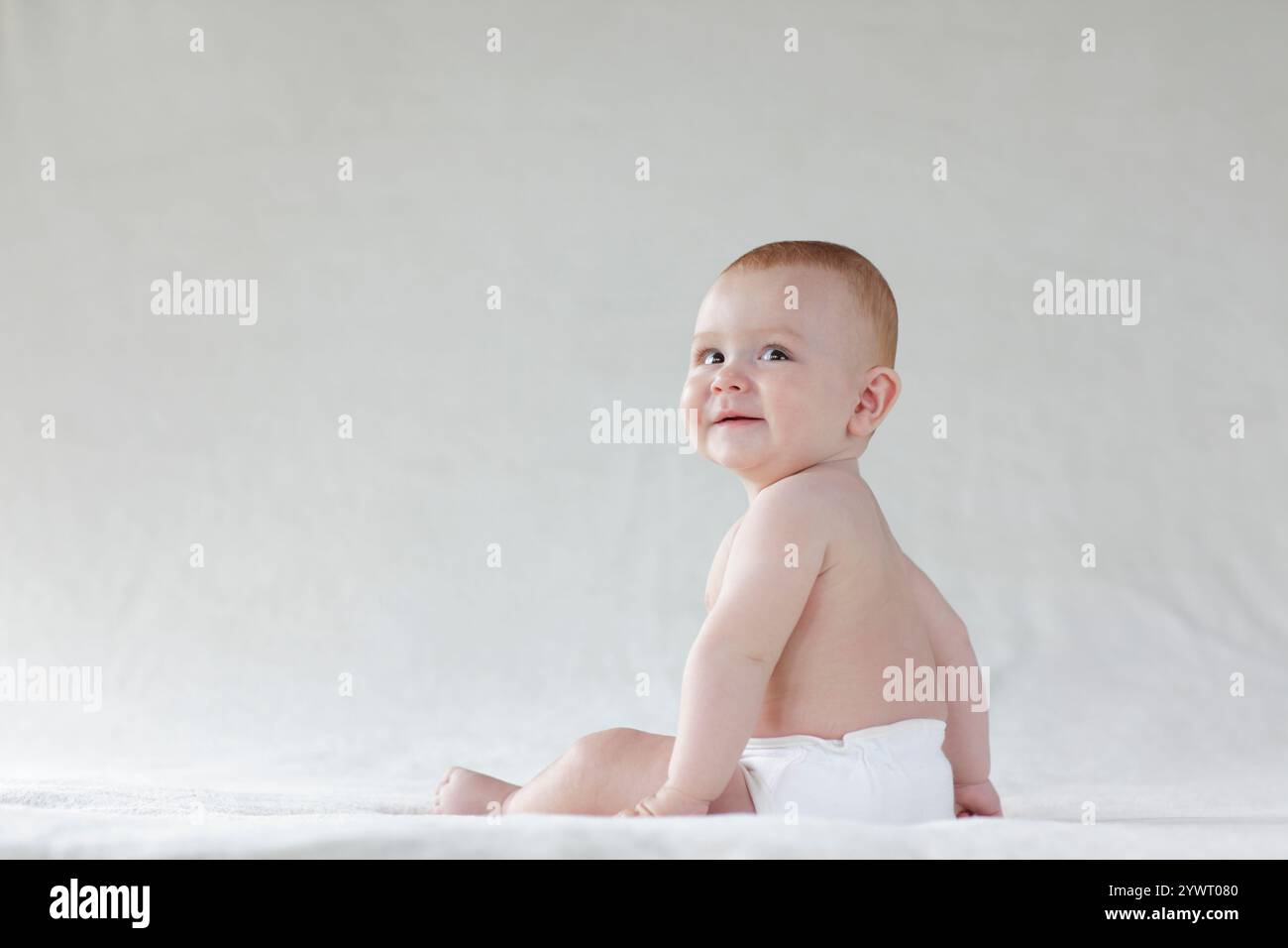 Foreign baby sitting on bed Stock Photo - Alamy