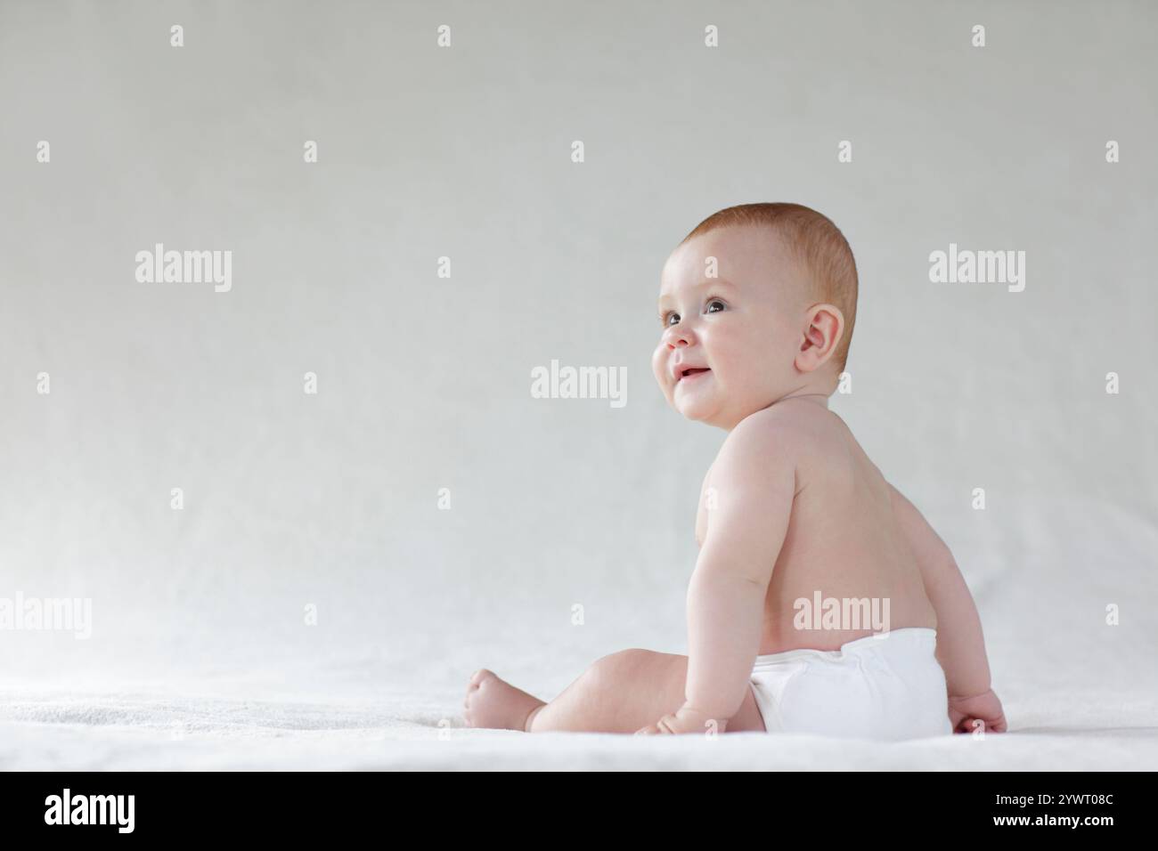 Foreign baby sitting on bed Stock Photo - Alamy