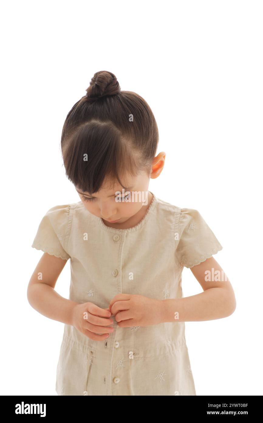 Girl trying her hand at buttoning Stock Photo - Alamy