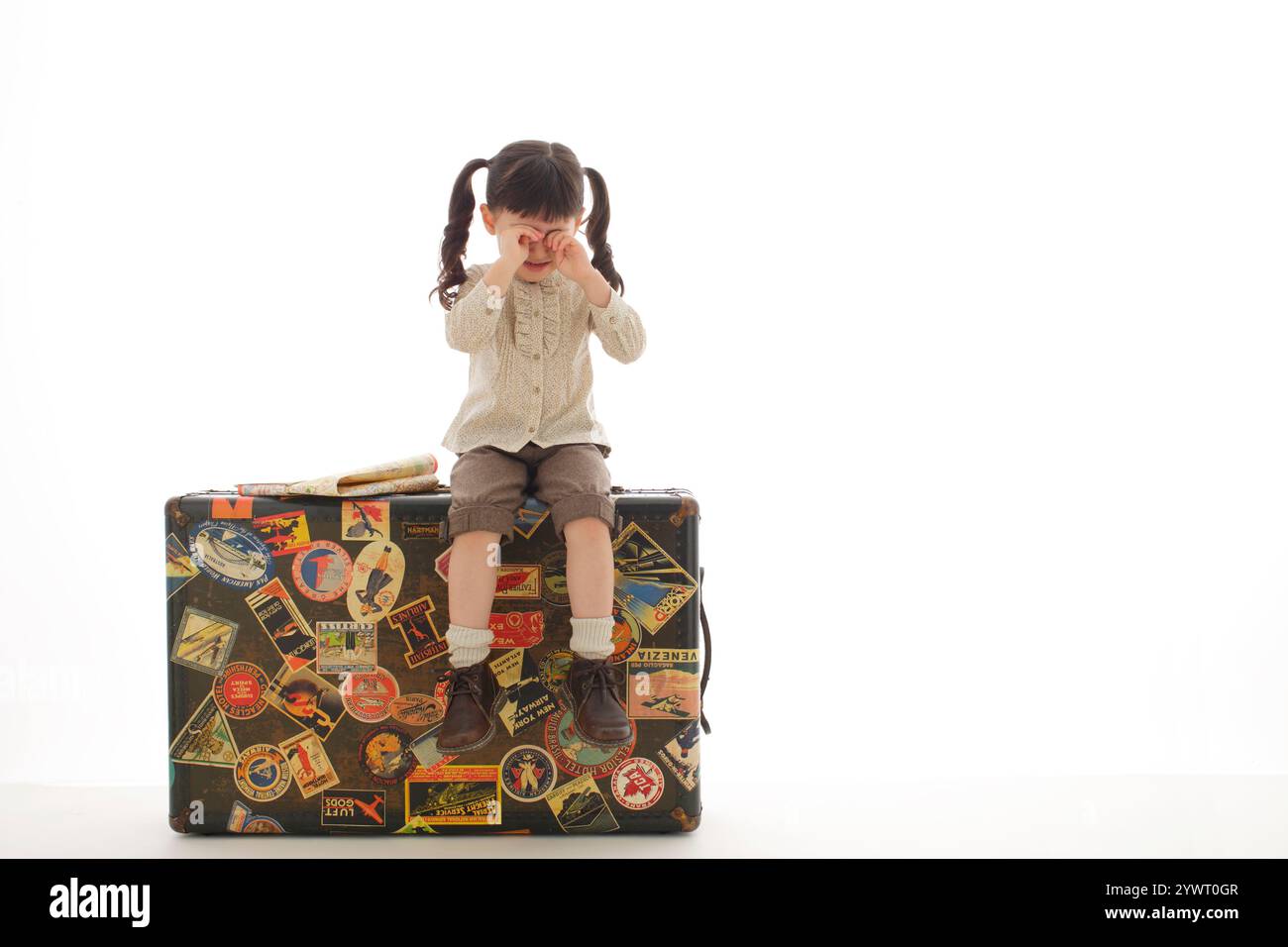 Lost girl sitting in suitcase and crying Stock Photo - Alamy
