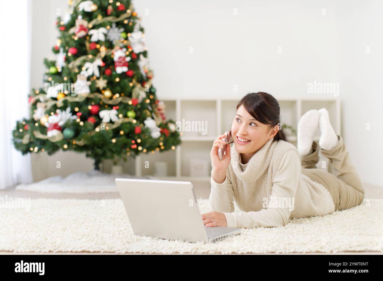 Woman enjoying communication in living room with Christmas tree Stock ...
