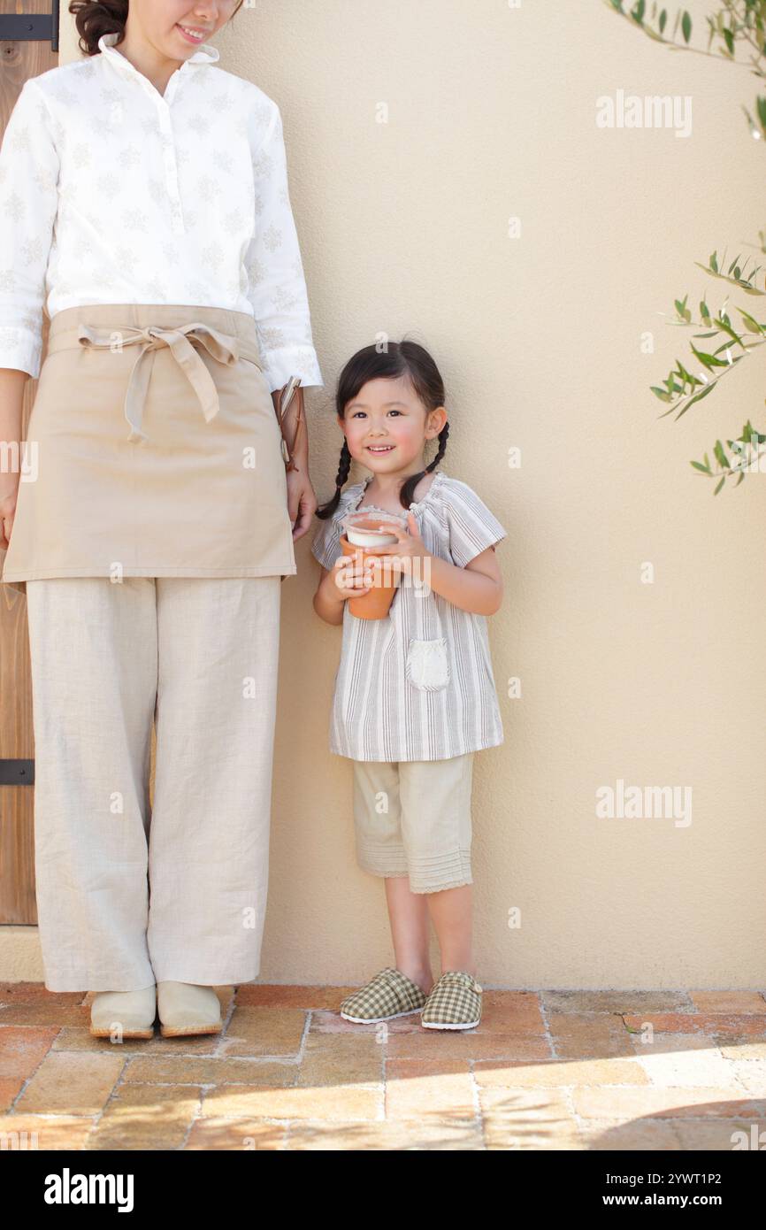 Mother and girl standing side by side in garden Stock Photo - Alamy