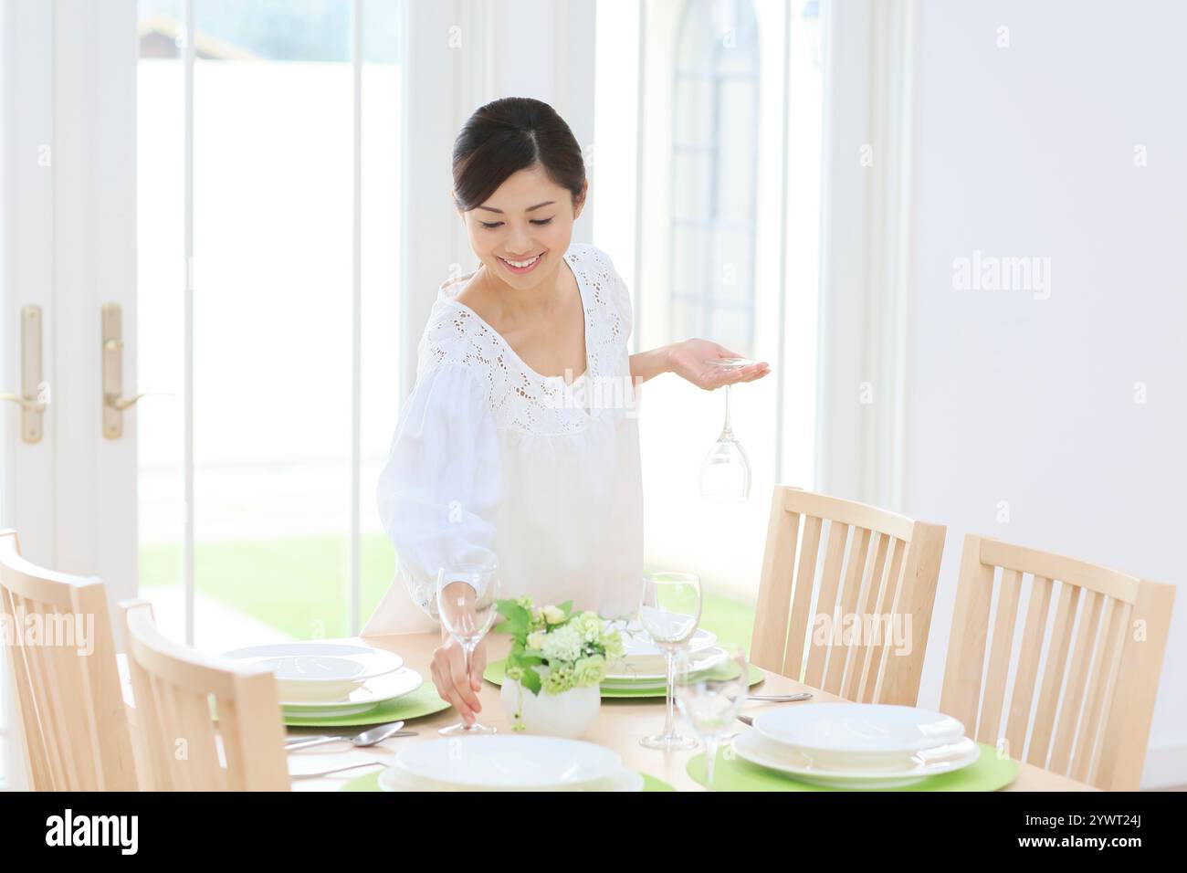 Woman setting a table Stock Photo - Alamy