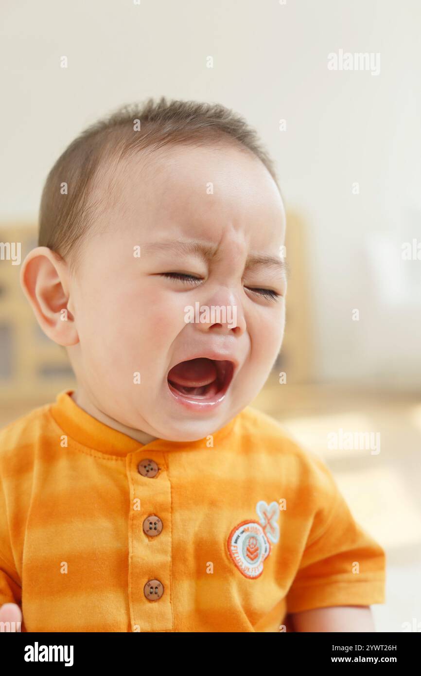 Baby crying in the living room Stock Photo - Alamy