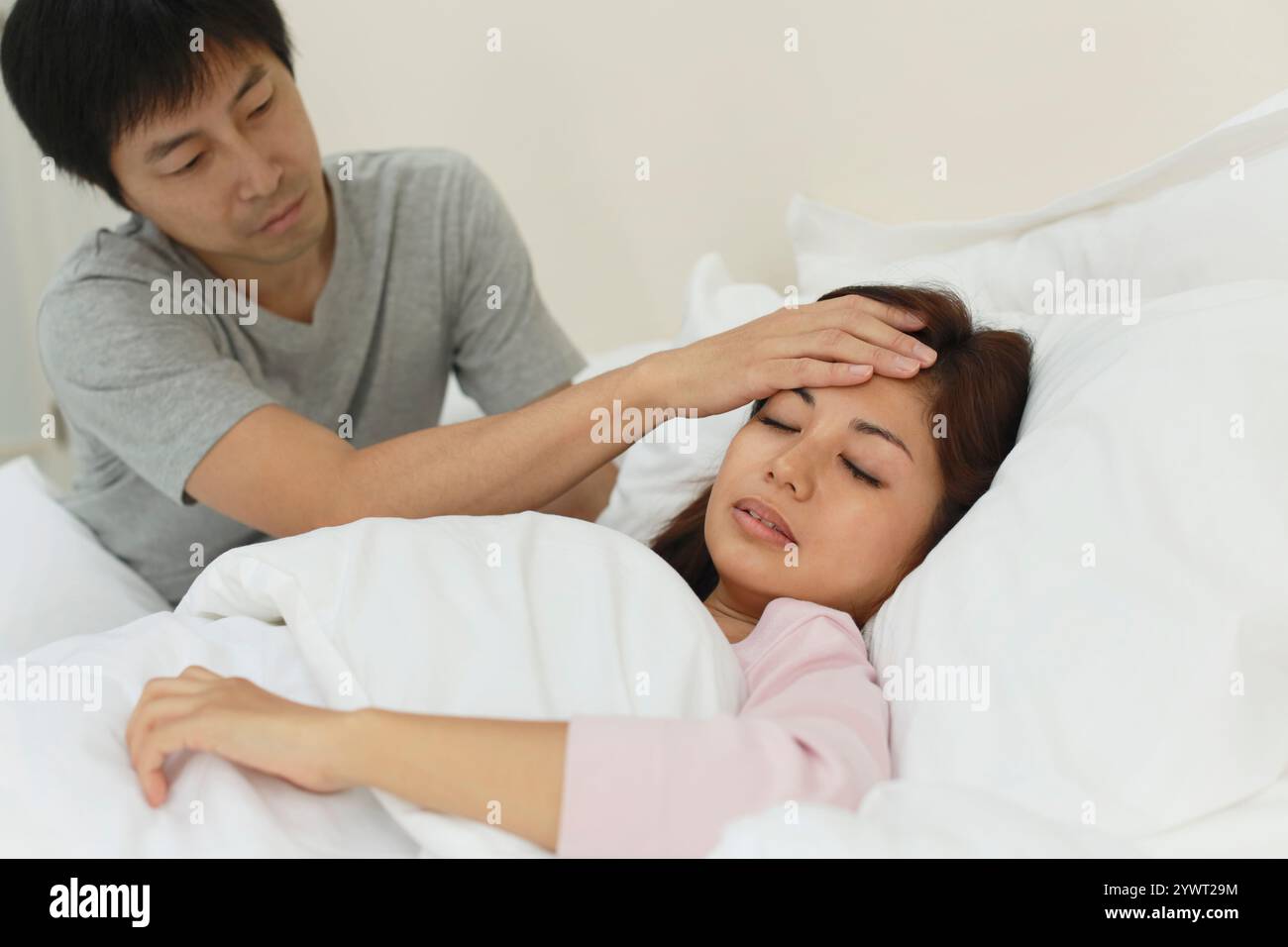 Husband looking after wife who is unwell Stock Photo - Alamy