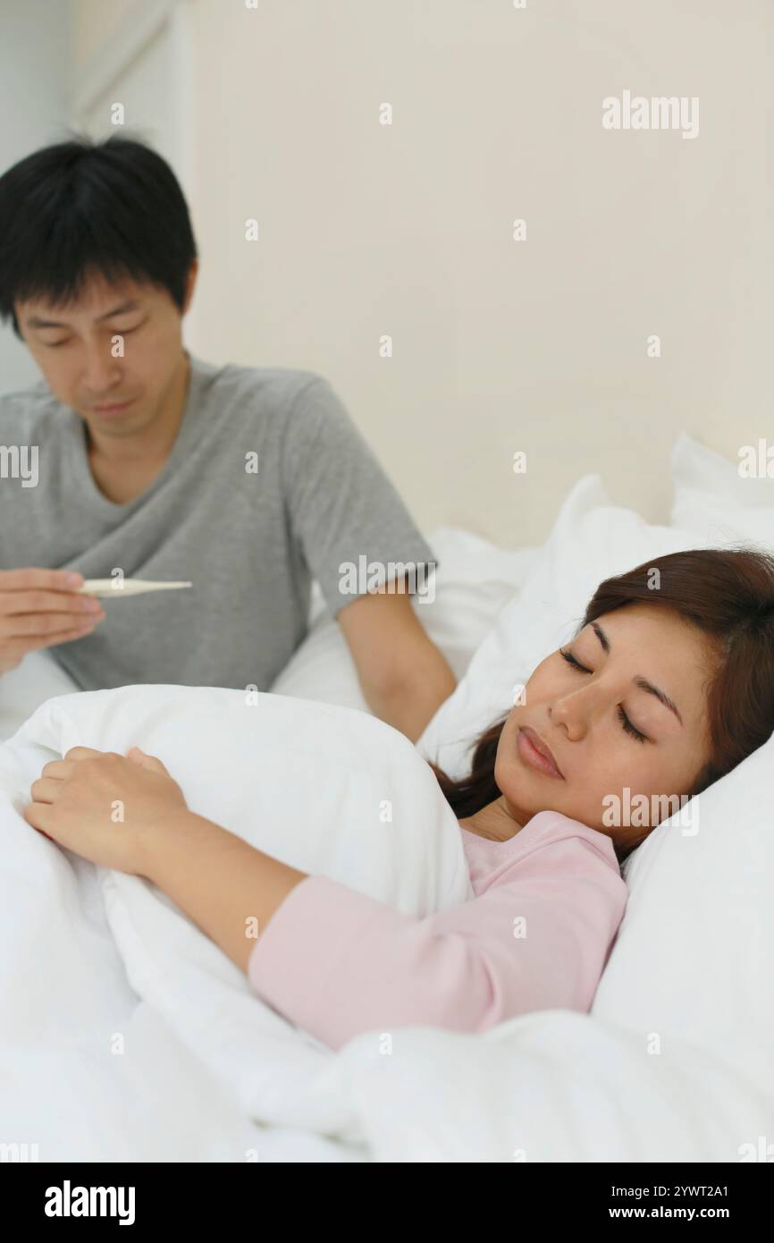 Husband looking after wife who is unwell Stock Photo - Alamy
