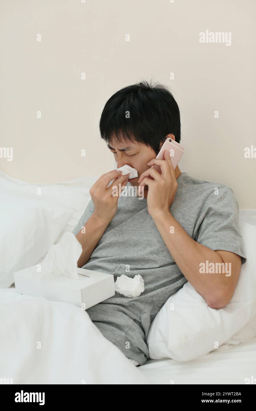 Man making a phone call while blowing his nose Stock Photo - Alamy