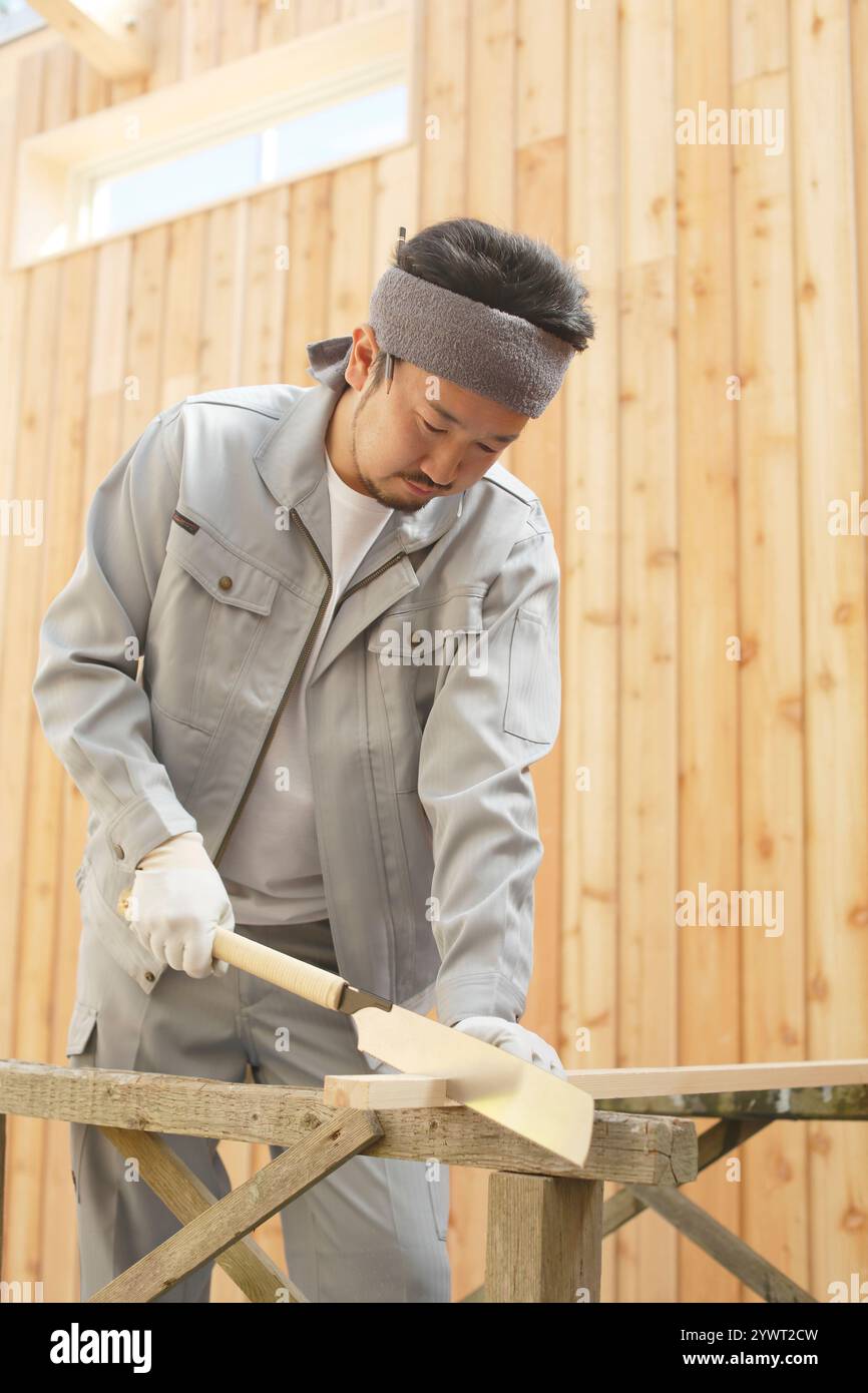 Carpenter man cutting timber Stock Photo - Alamy