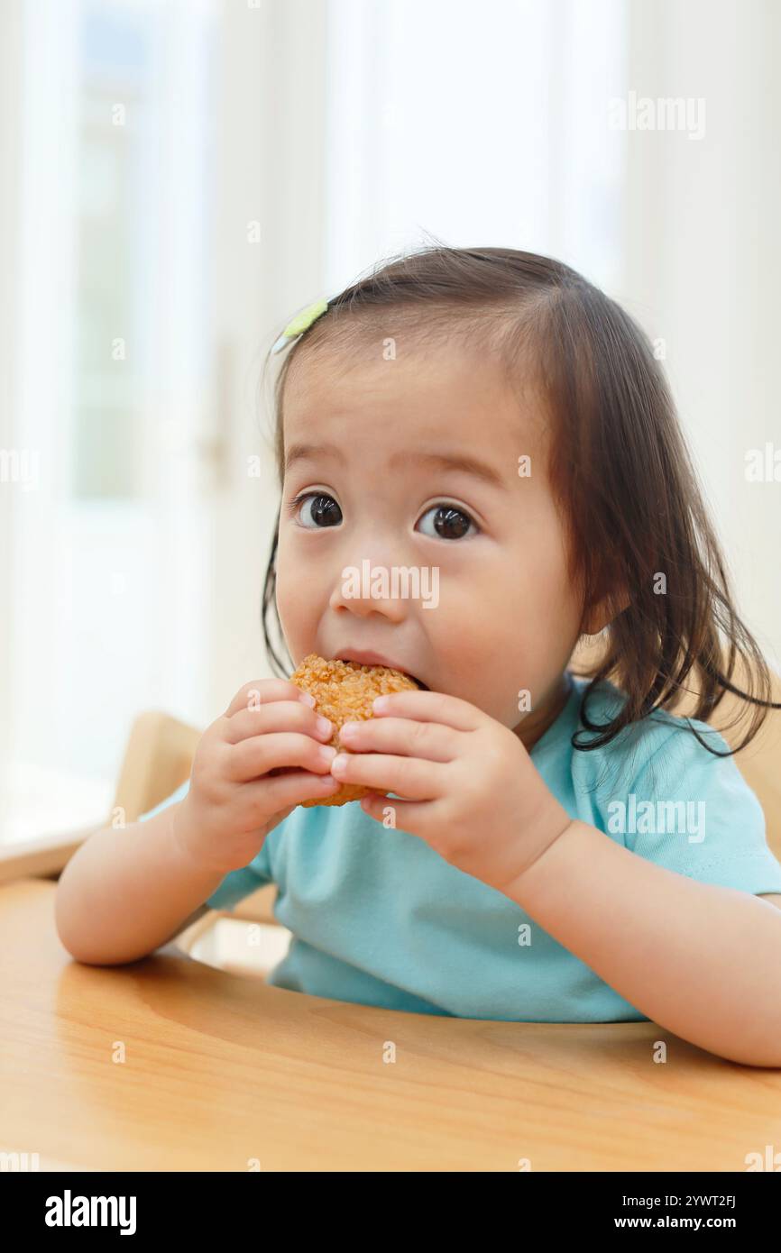 Girl eating grilled onigiri Stock Photo - Alamy