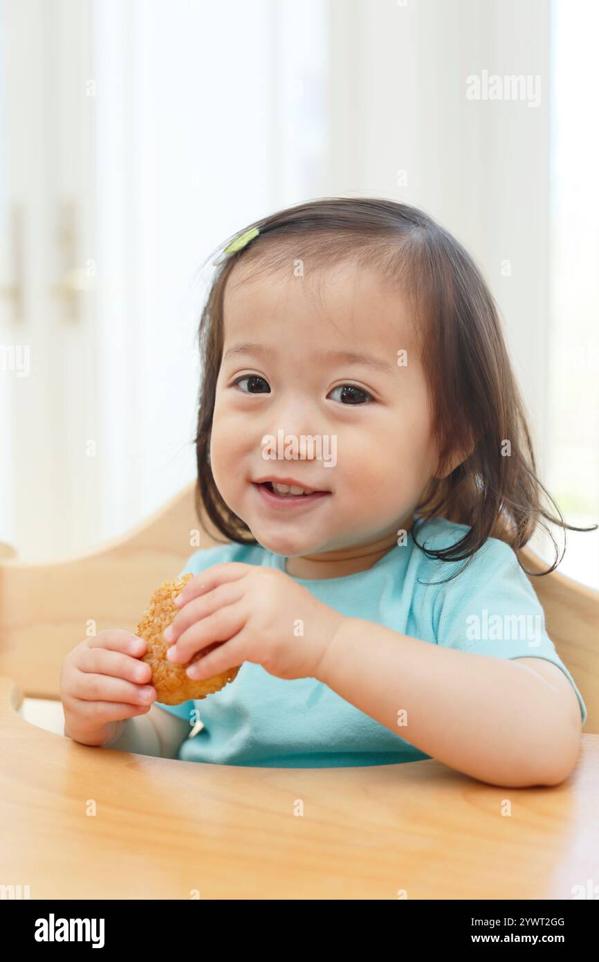 Girl eating grilled onigiri Stock Photo - Alamy