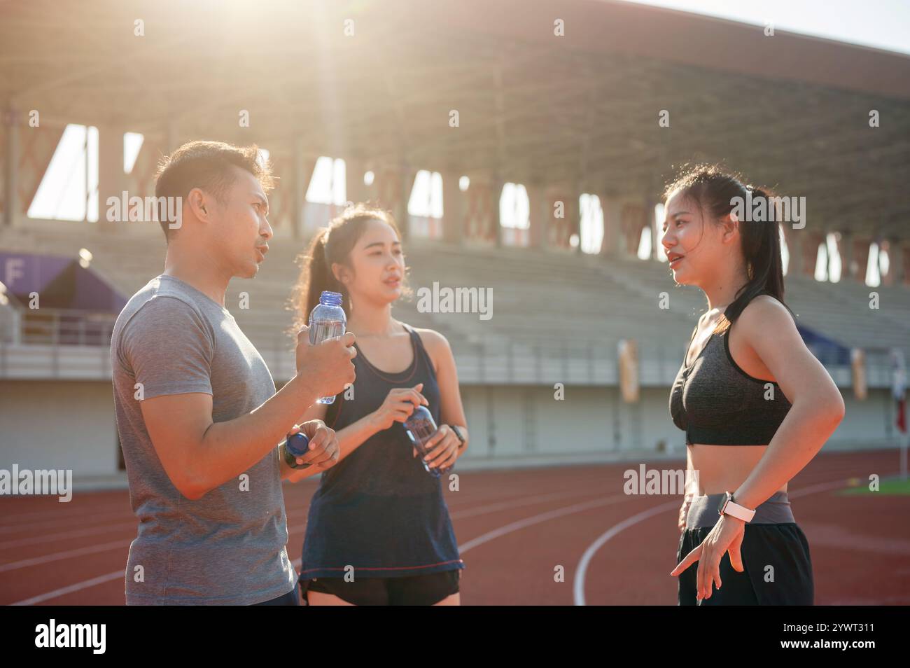 A group of Asian athlete runners enjoy a conversation while resting on ...