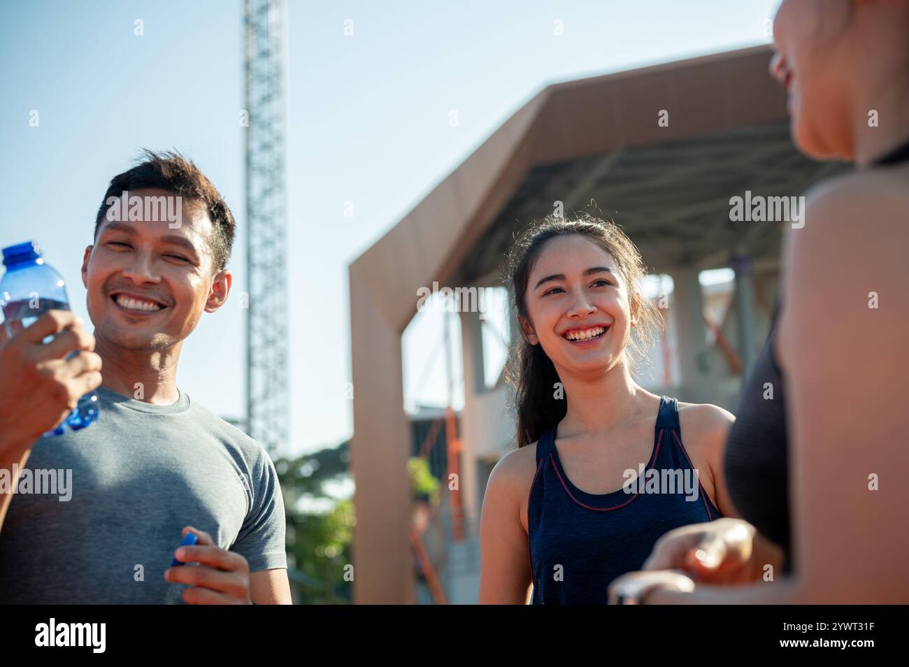 A group of Asian athlete runners enjoy a conversation while resting on ...