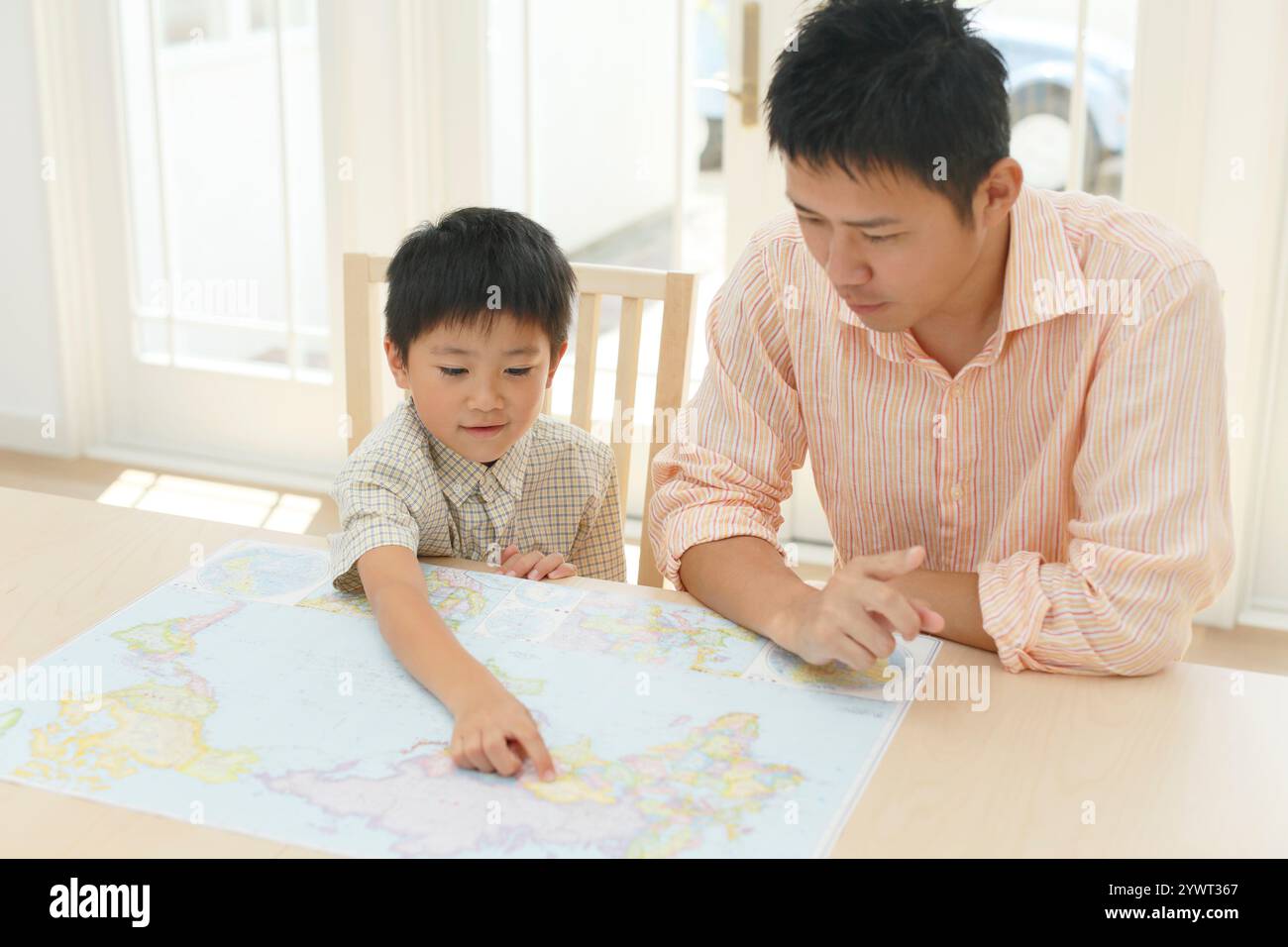 Father and child spreading map at table Stock Photo - Alamy